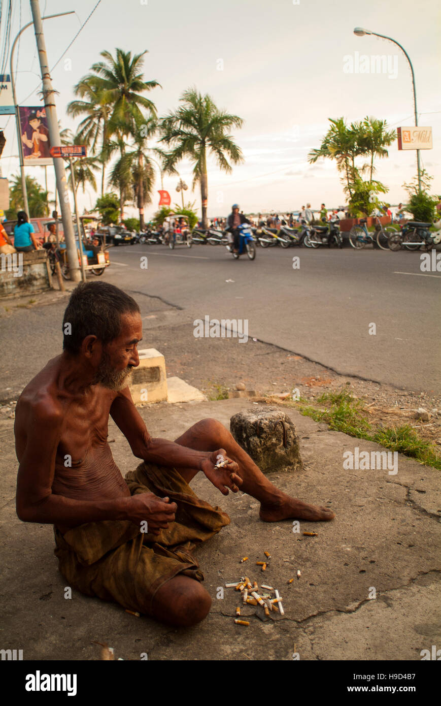 A begger sitting on the street at the waterfront in the city of ...
