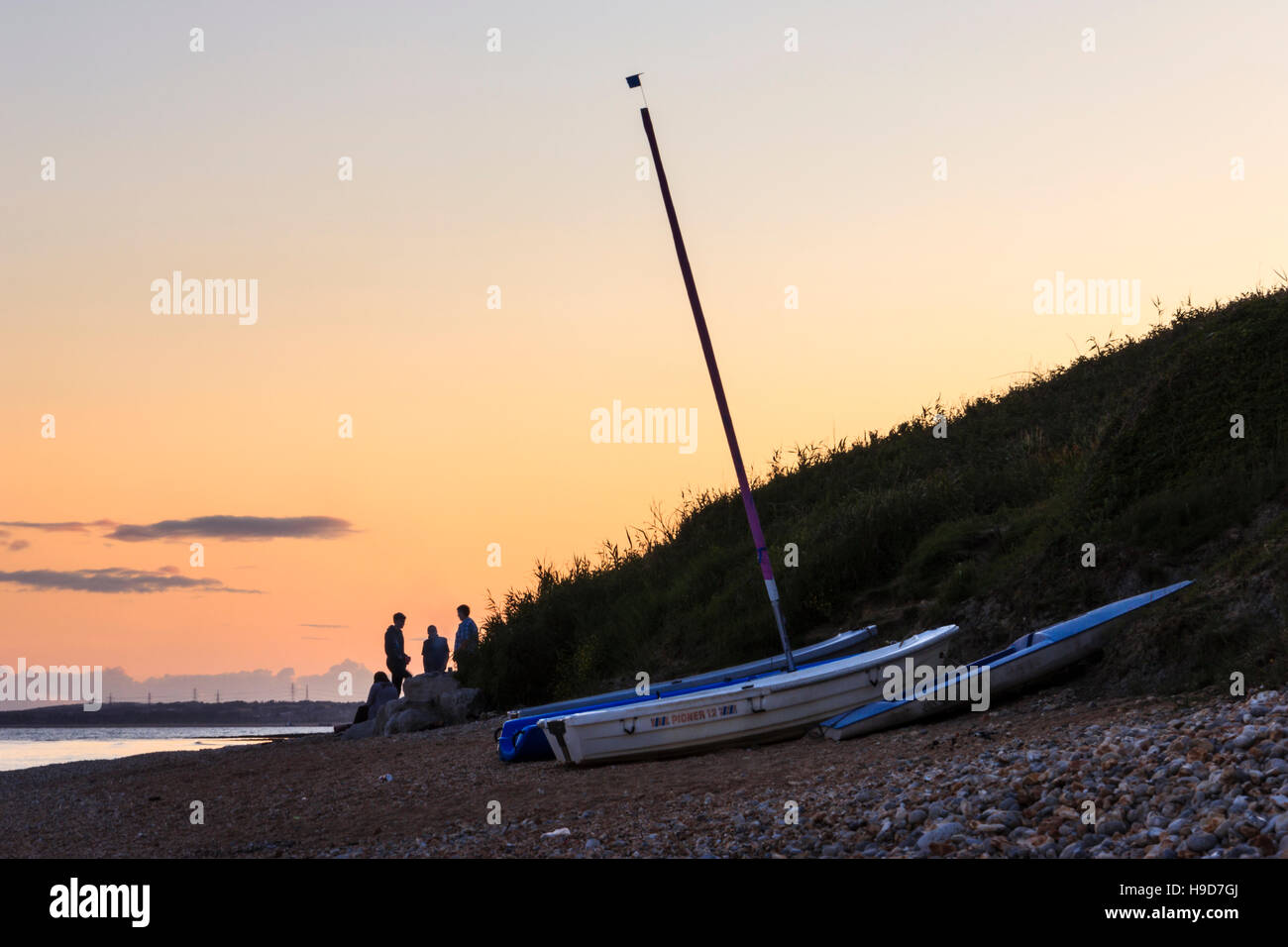 Sunset on the beach at Ringstead Bay, Dorset, England, UK, a group of ...