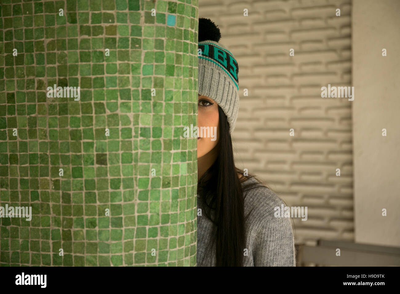 girl posing in winter style behind a column Stock Photo - Alamy