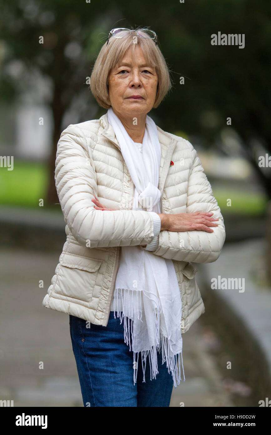 Vertical shot of fashionable old Japanese lady outside stood with arms ...