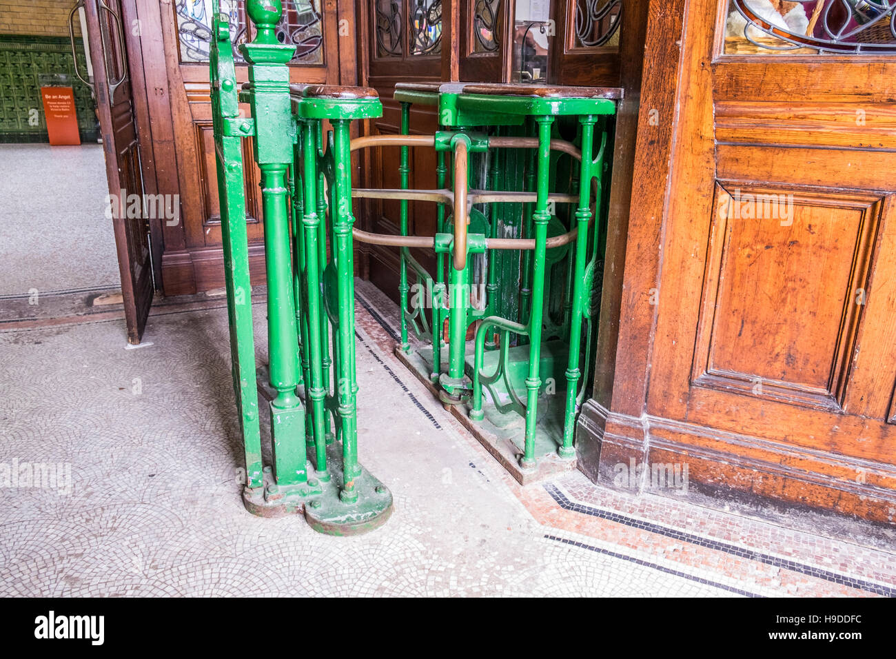 A green old fashioned turnstile allowing people into a building Stock ...