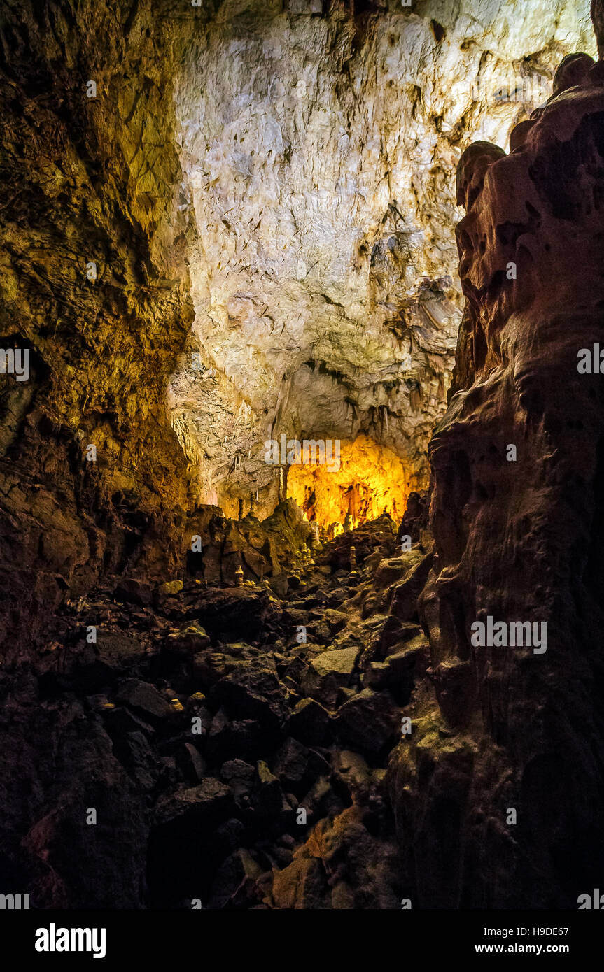 cave with colourful textured walls and stalactites and stalagmite lit ...