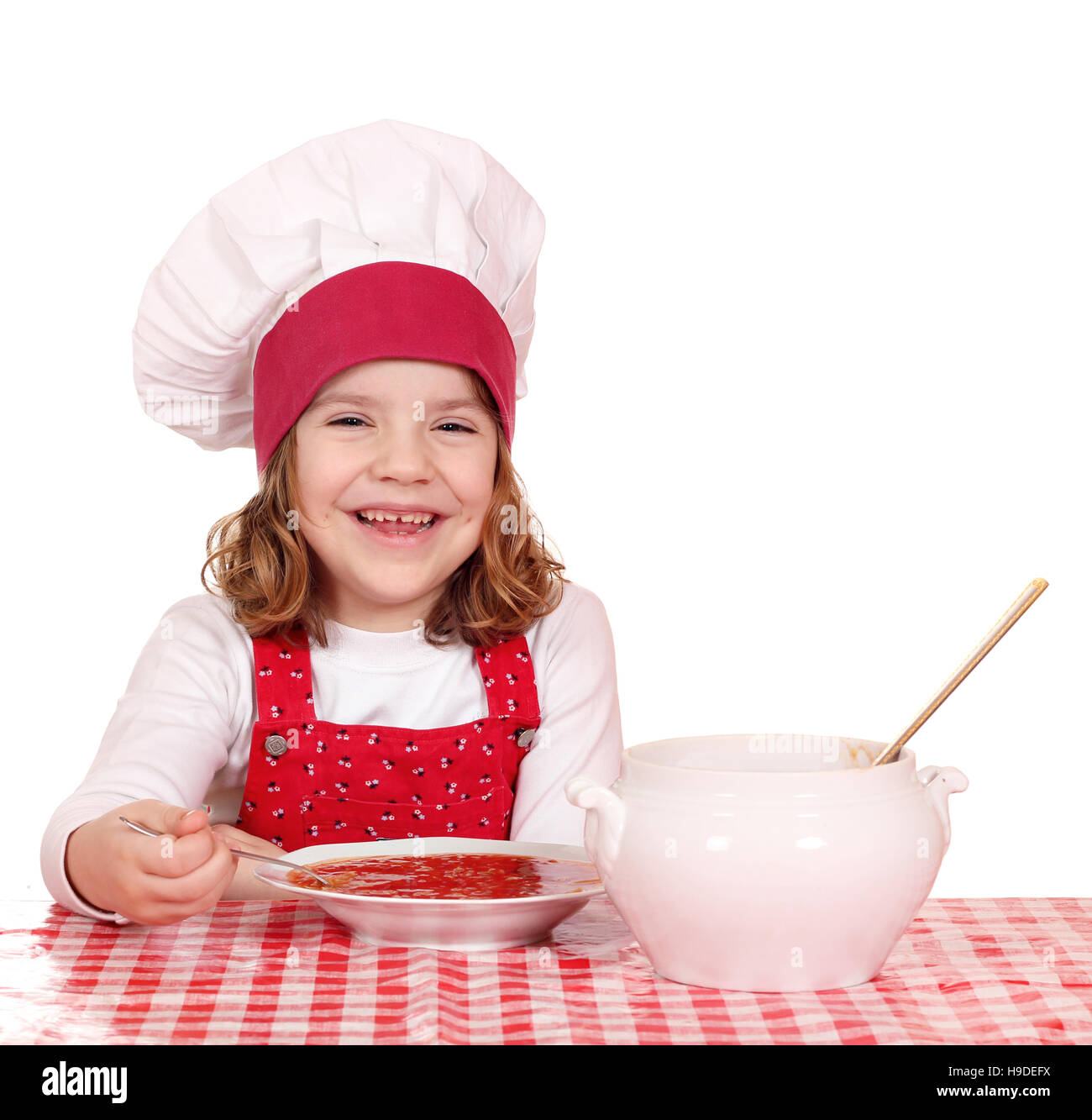 happy little girl cook eat soup Stock Photo - Alamy