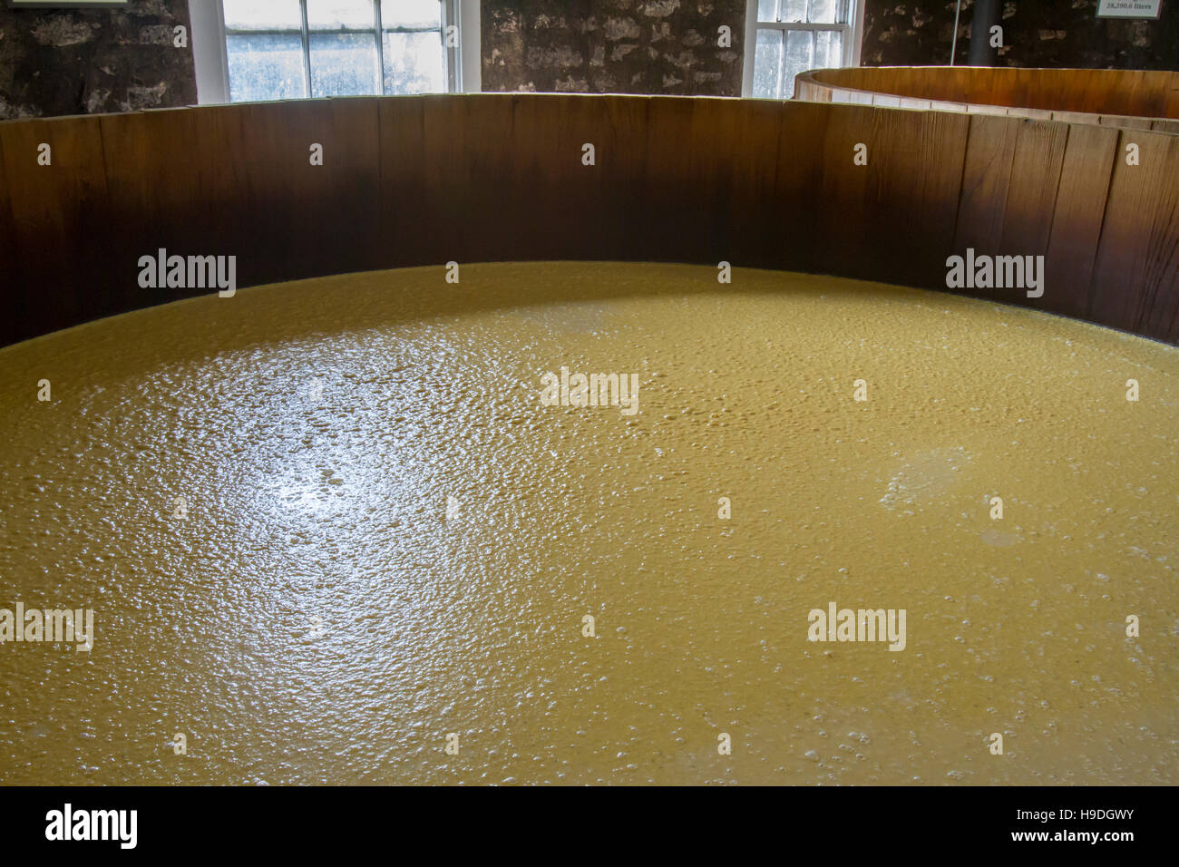 Mash in oak barrel fermentation tanks inside stone distillery Stock ...