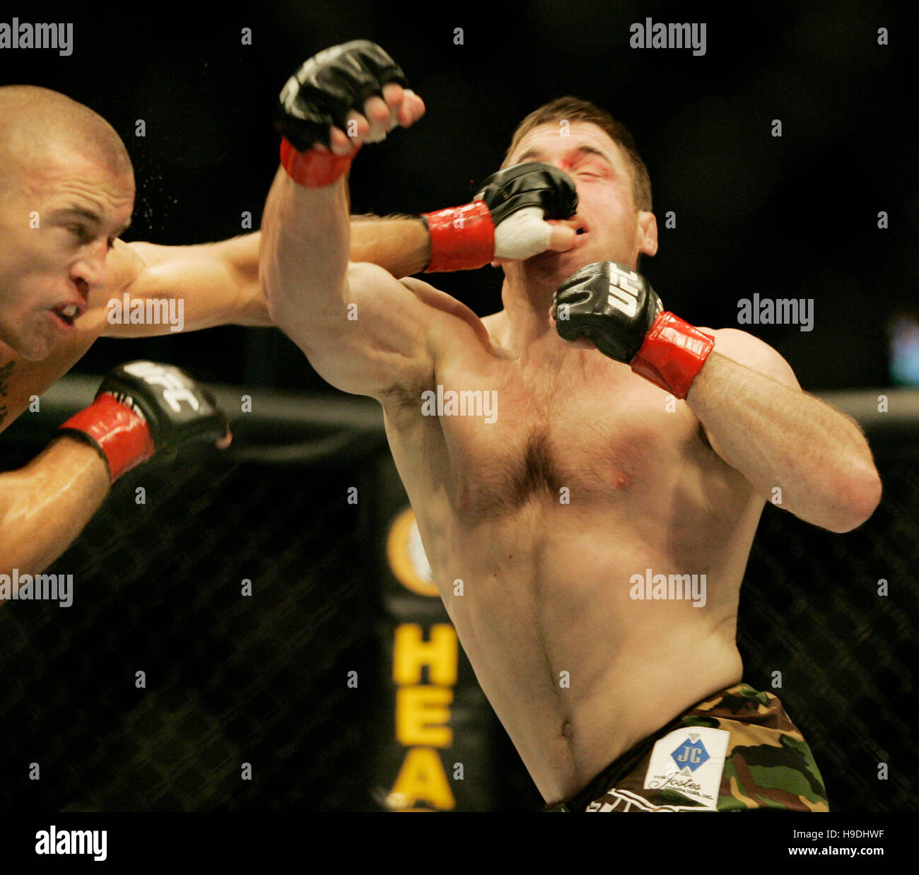 Georges St. Pierre, left, punches Matt Hughes during the Ultimate ...