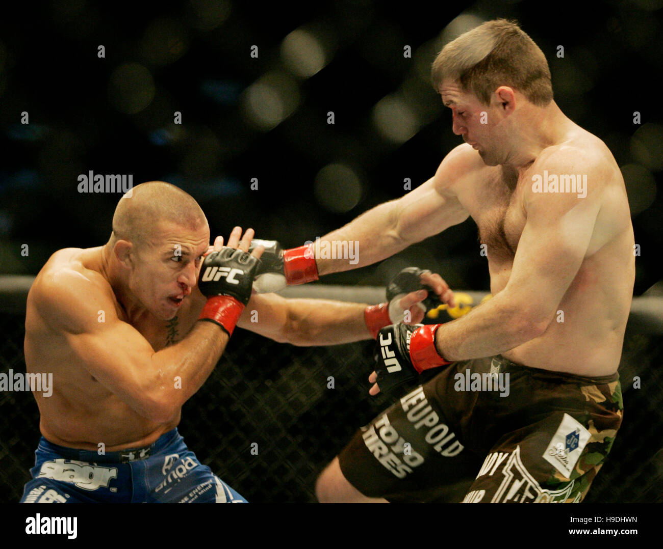 Georges St. Pierre, left, punches Matt Hughes during the Ultimate ...