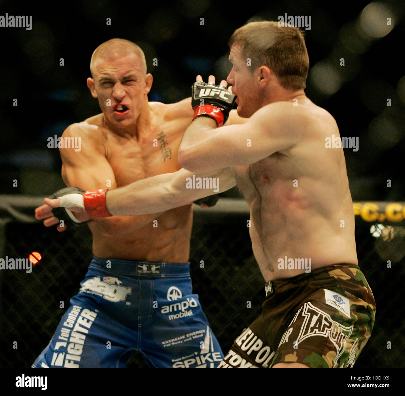 Georges St. Pierre, left, punches Matt Hughes during the Ultimate ...
