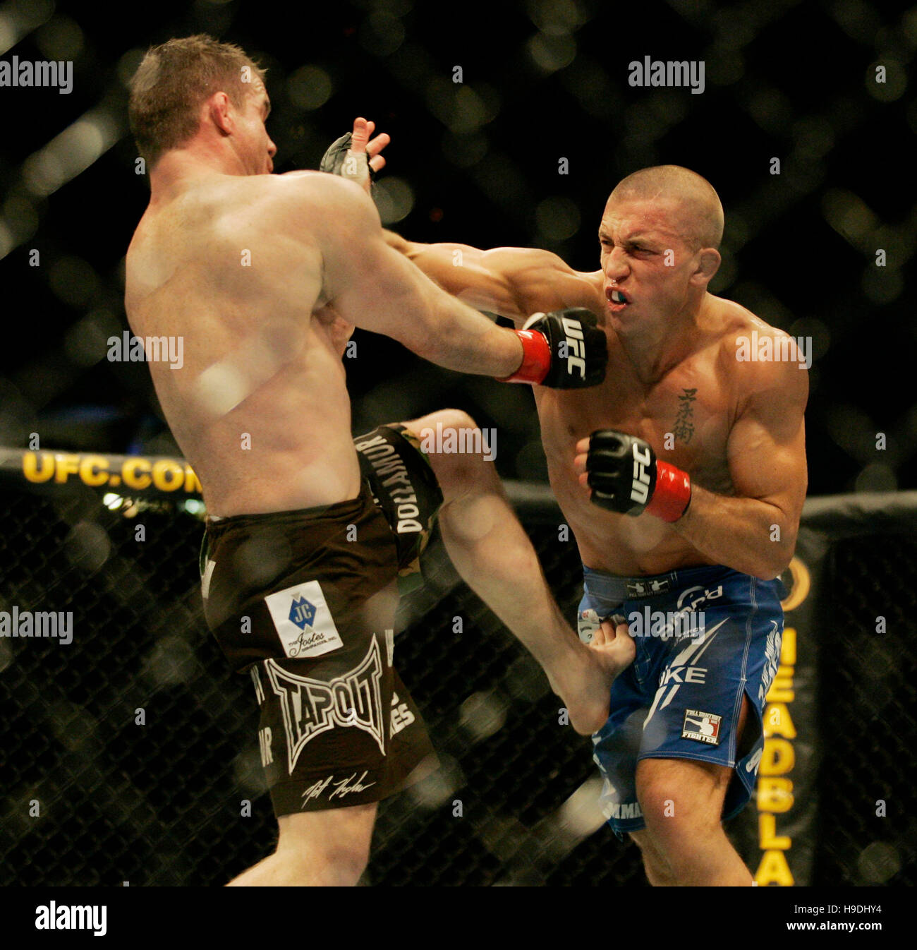 Georges St. Pierre, right, punches Matt Hughes during the Ultimate ...