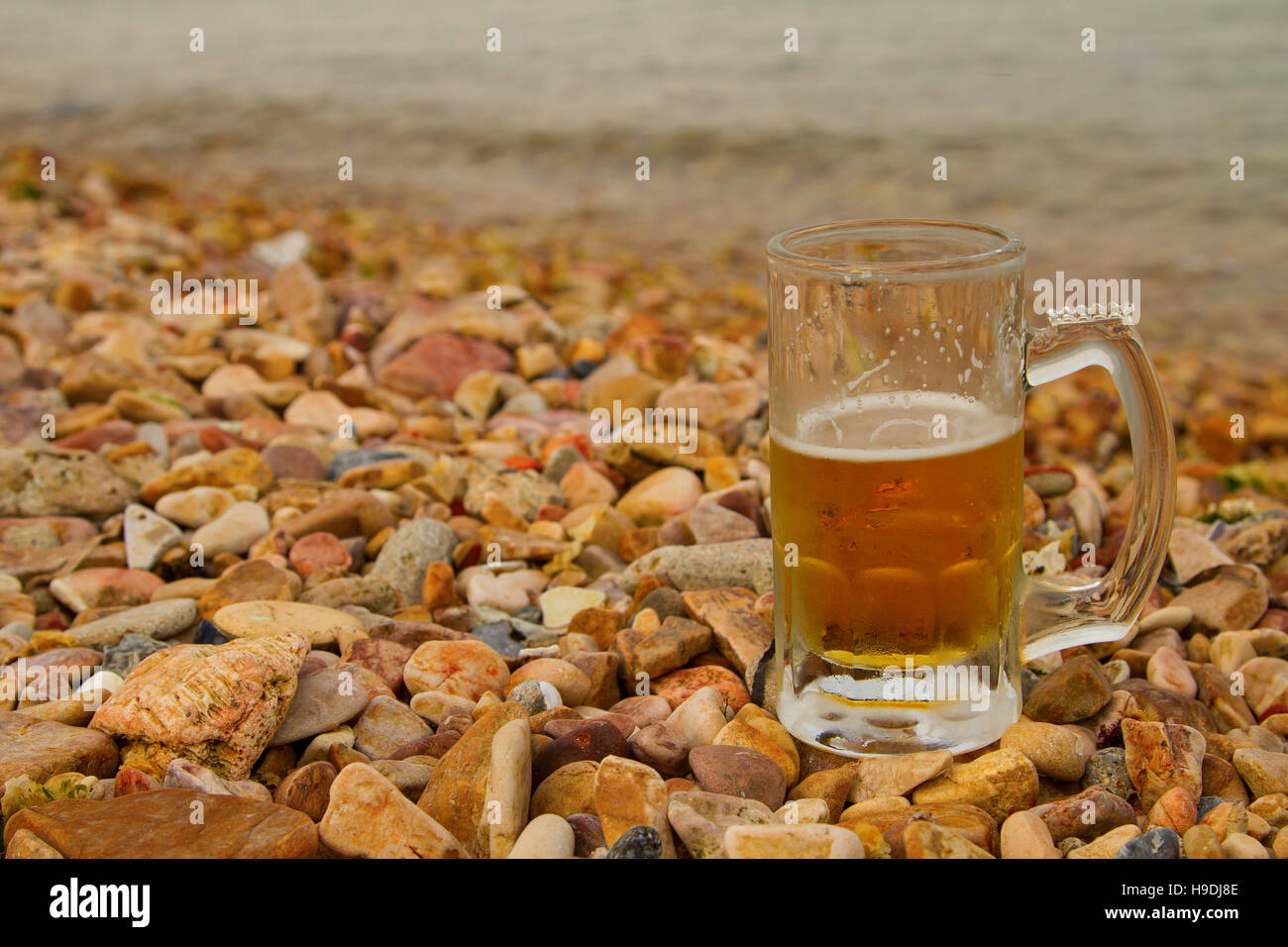 Glass of beer on the pebble beach Stock Photo - Alamy
