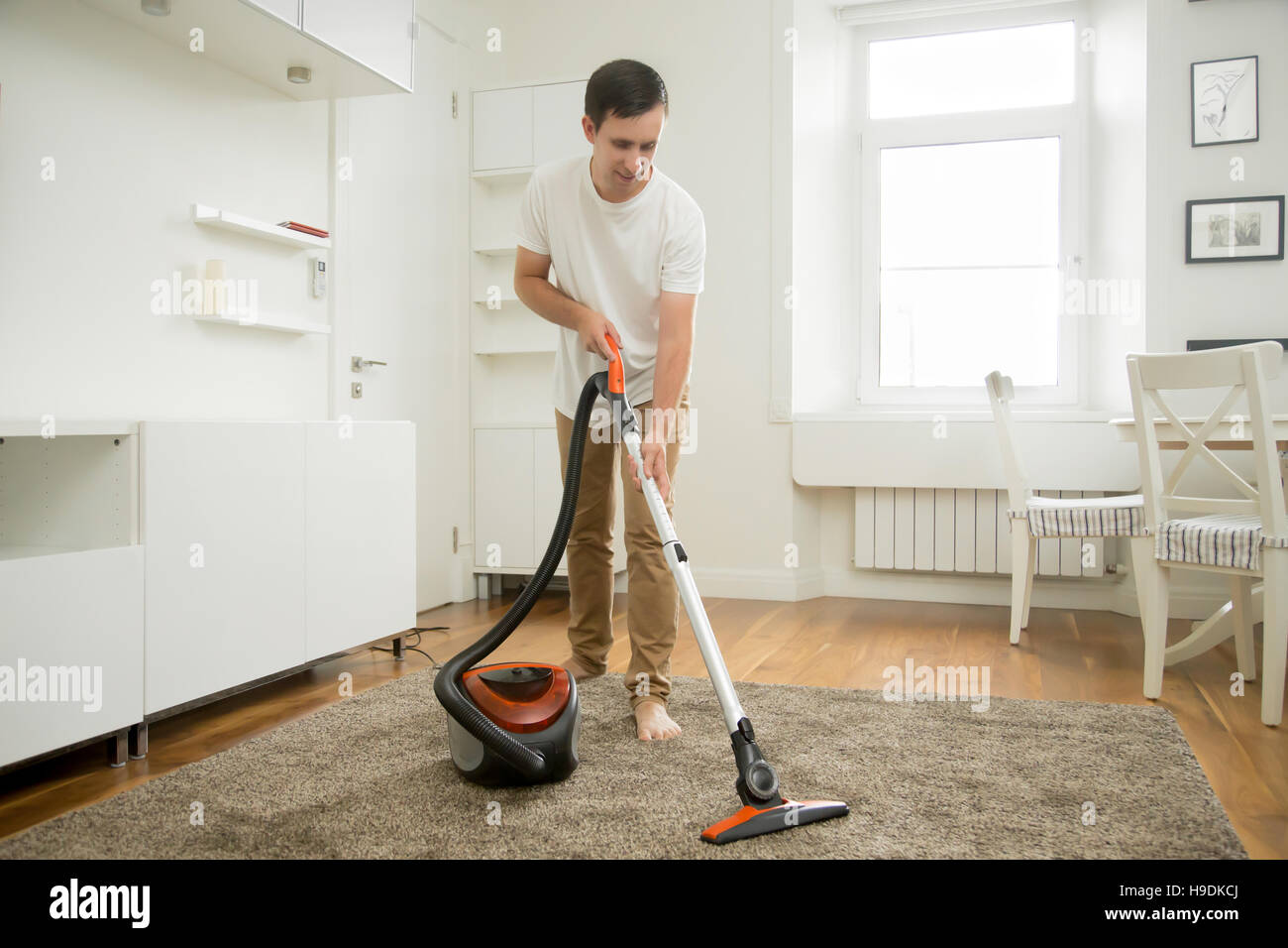 Happy smiling man cleaning the carpet Stock Photo - Alamy