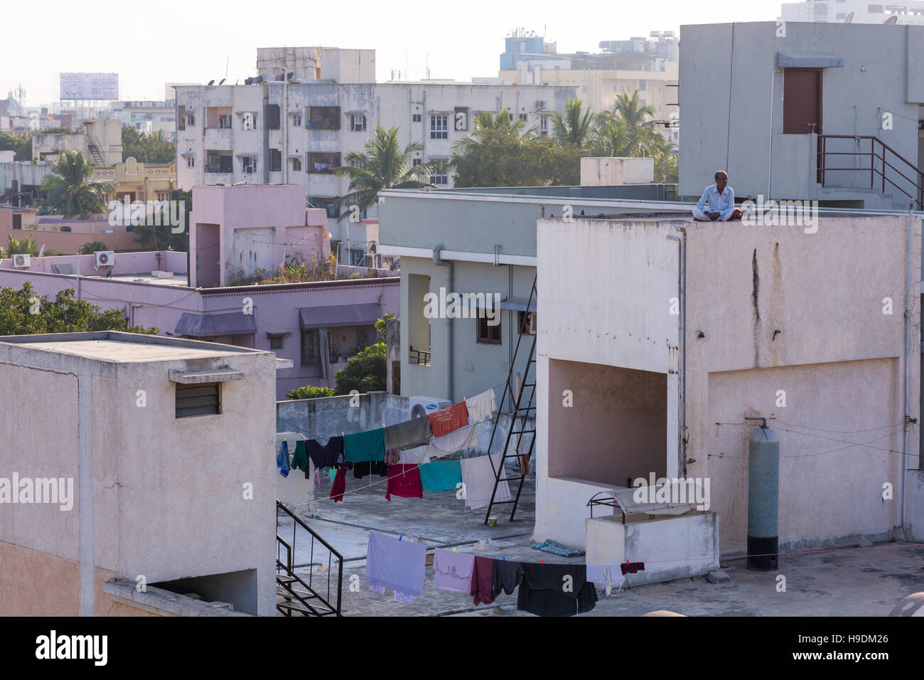 Indian man sitting alone on the roof late afternoon enjoying his own ...