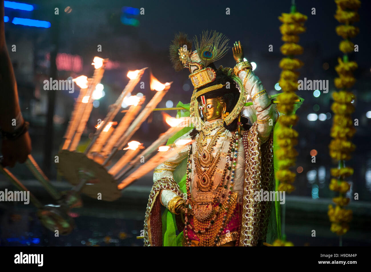 Hindu priest performs the Aarti ritual in front of lord krishna idol at ...