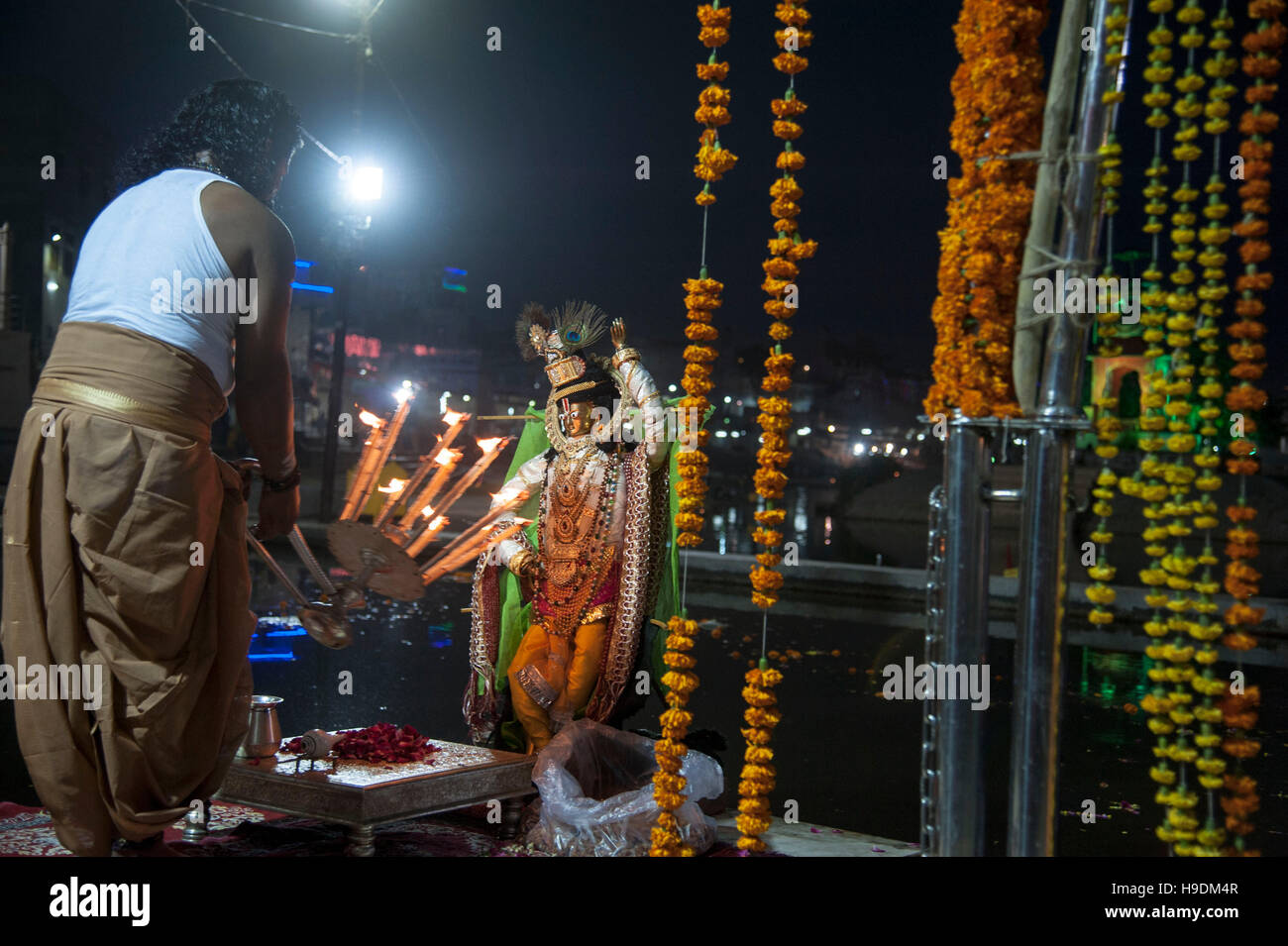Hindu priest performs the Aarti ritual in front of lord krishna idol at ...