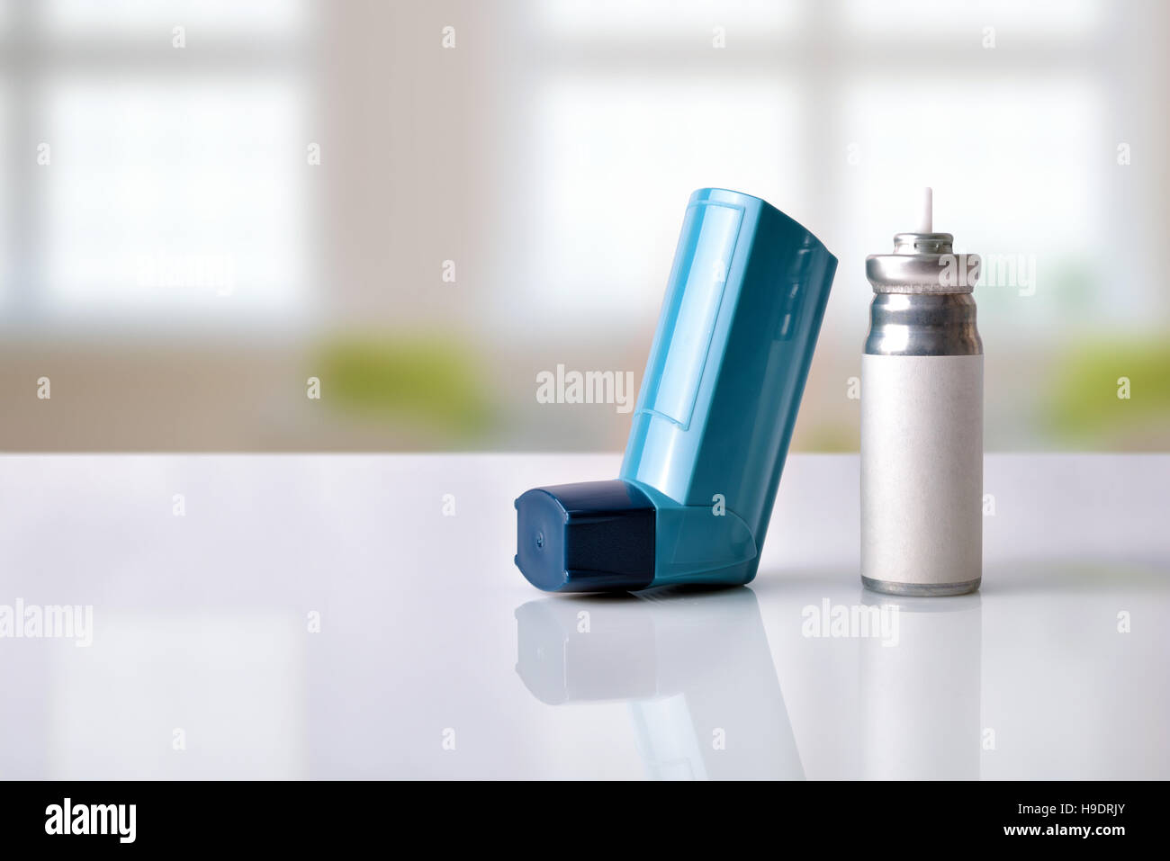 Cartridge and blue medicine inhaler on white glass table in a room ...