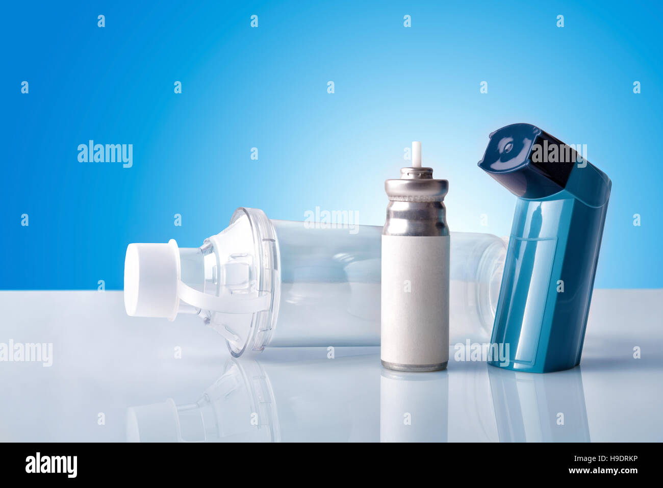 Cartridge, blue medicine inhaler and inhalation chamber on white glass ...