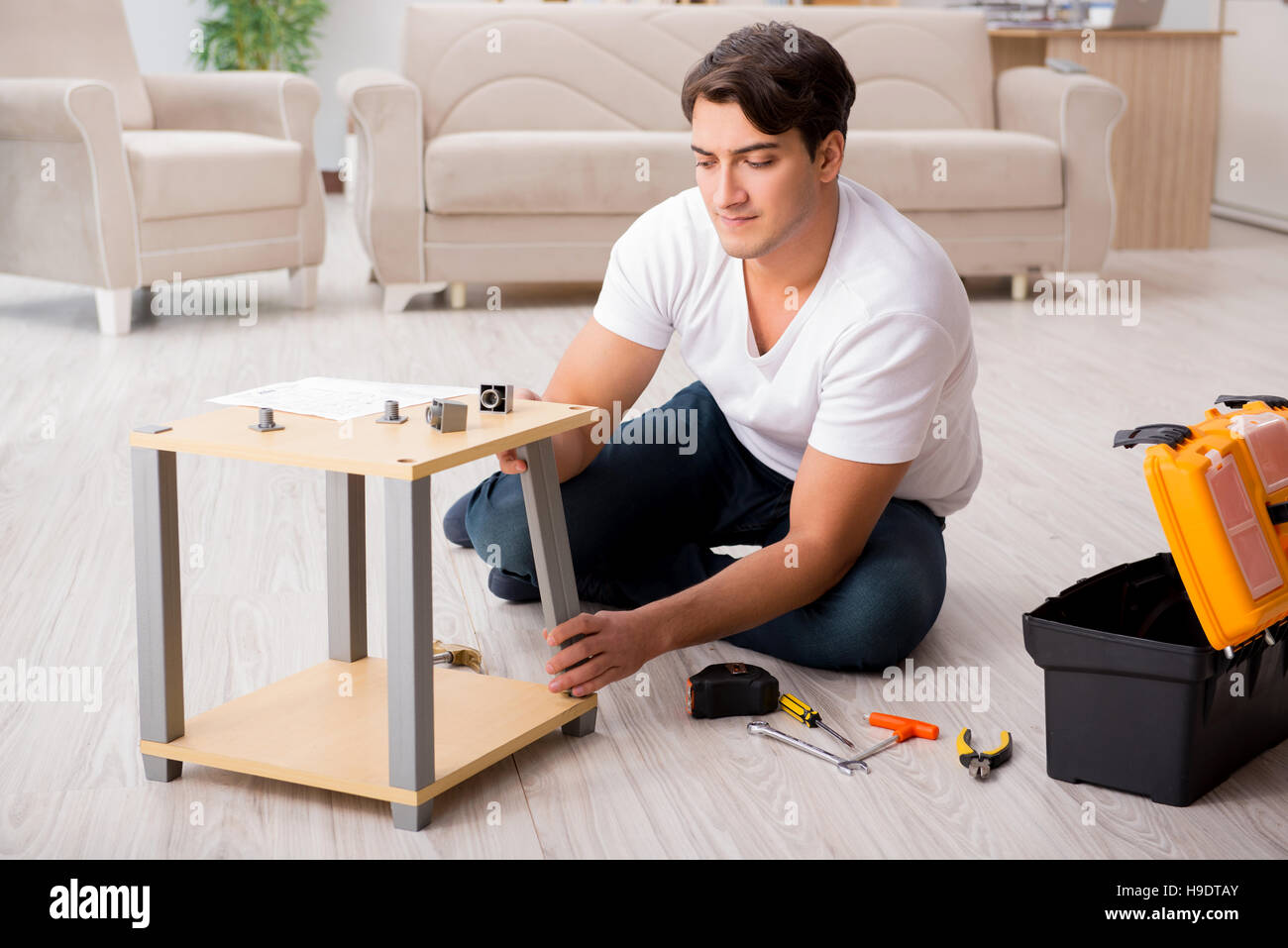 Man assembling shelf at home Stock Photo - Alamy