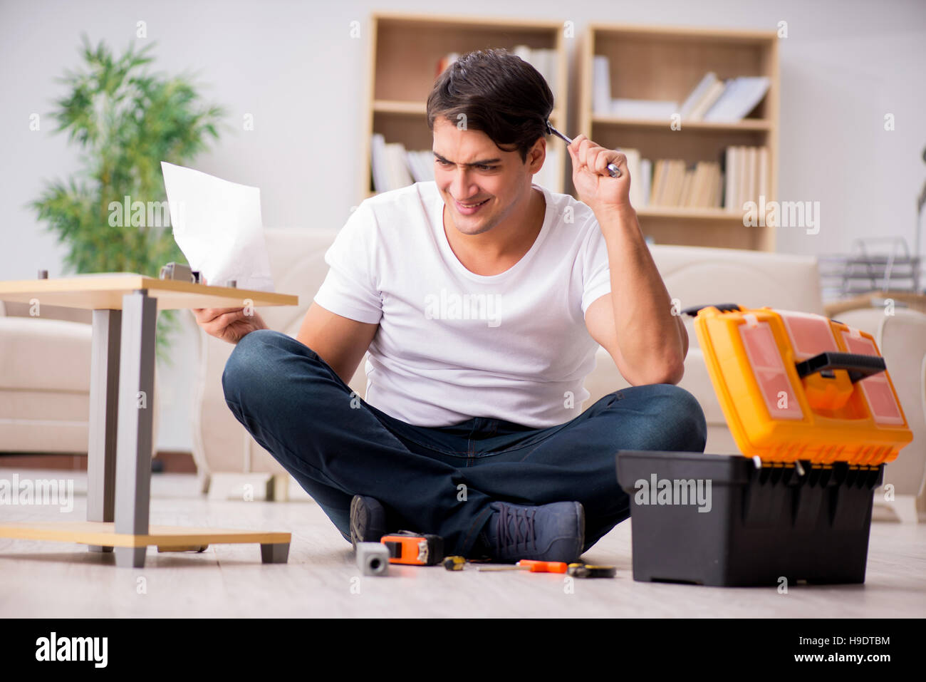 Man assembling shelf at home Stock Photo - Alamy