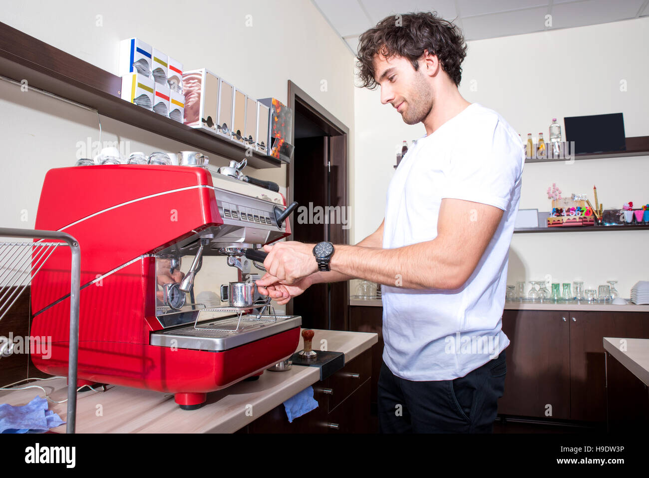 A handsome young man making coffee at the bar in a coffee shop Stock ...