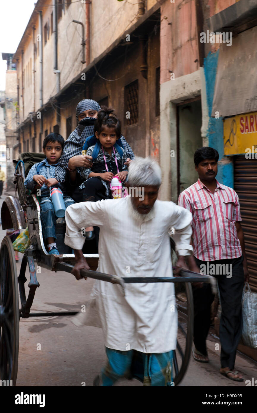 A man pulls an Muslim family through a Calcutta back street in his ...