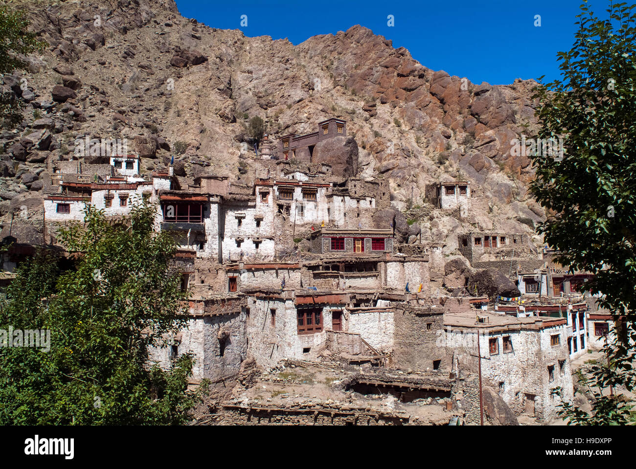 The plum coloured Hemis Gompa sitting above a collage of stone grey and ...