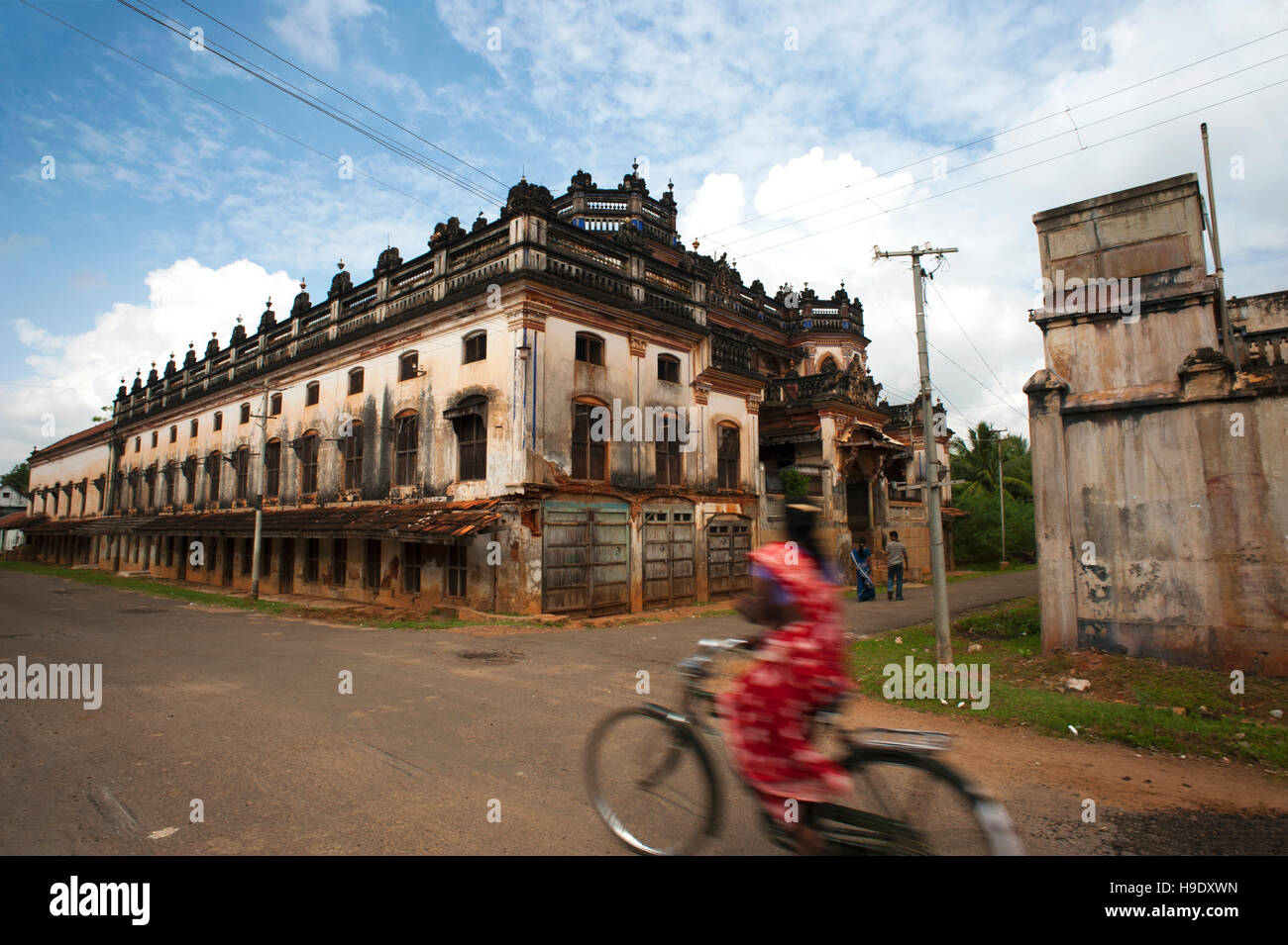 A woman cycles past a discarded mansion in Kanadukathan village in ...