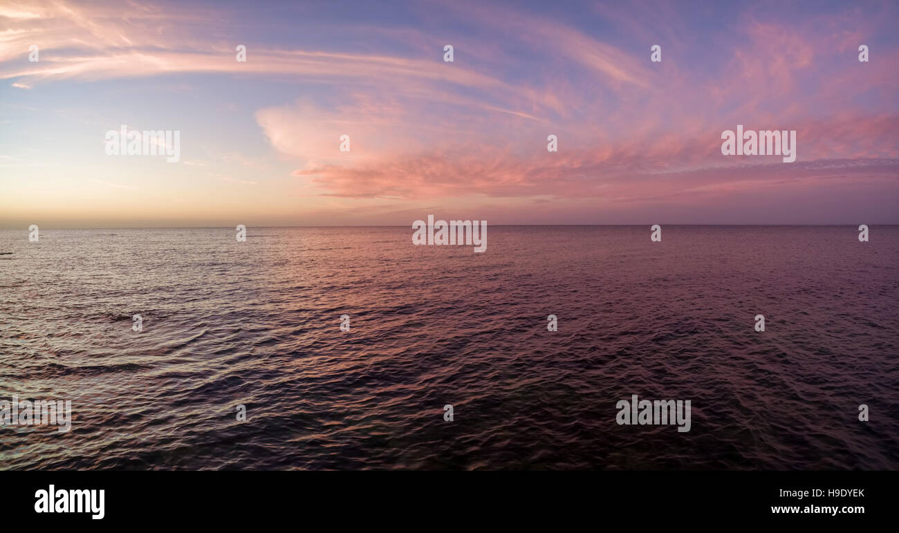 Aerial panorama of sunset over ocean. Nothing but sky, clouds and water ...