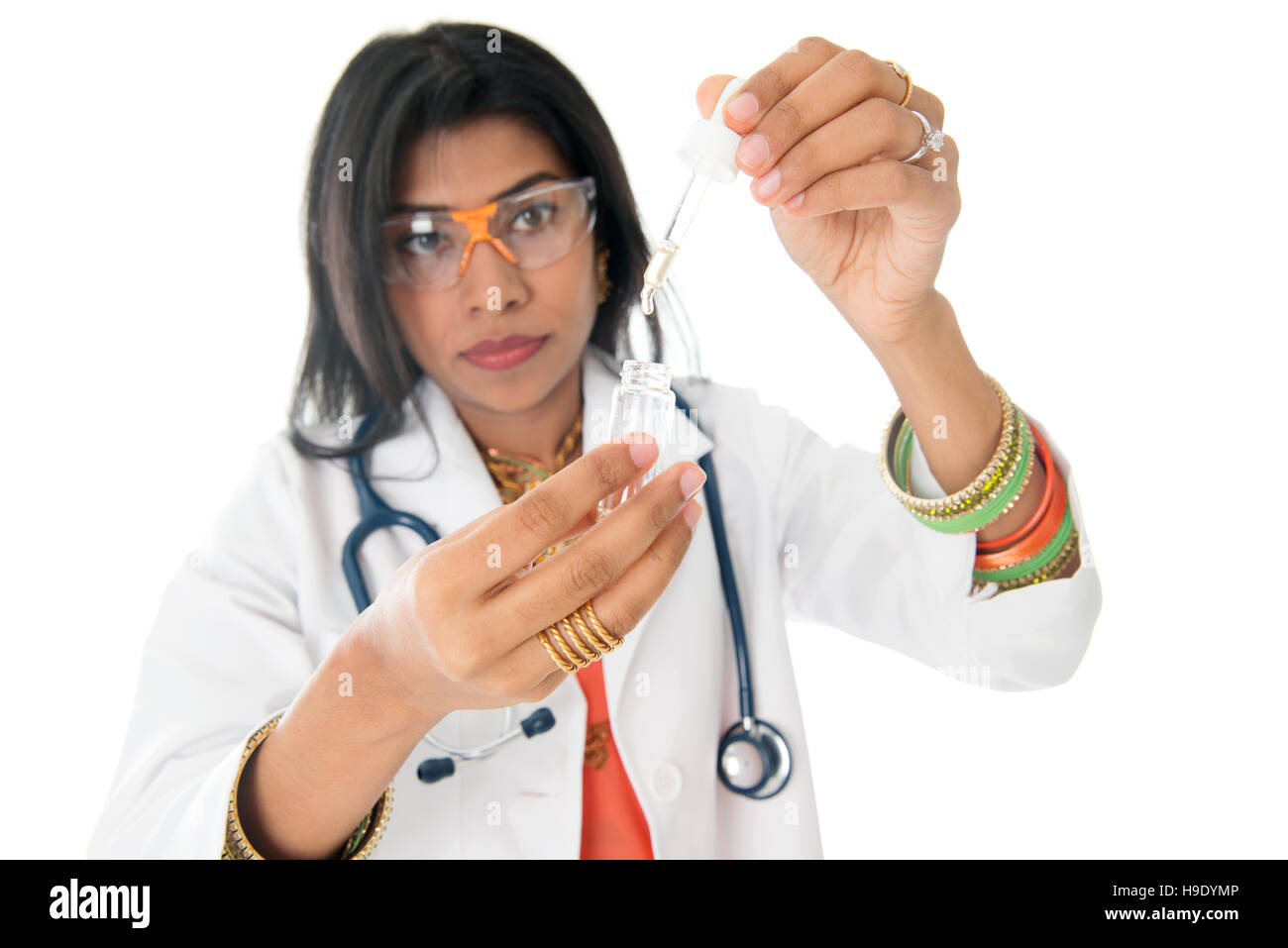An Indian female medical doctor looking at a test liquid in a ...