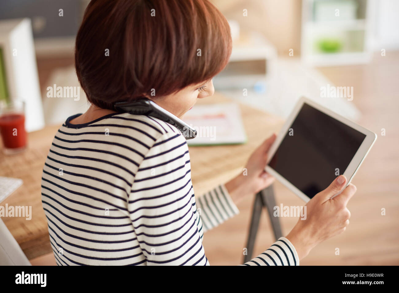 Rear view of multitasking woman Stock Photo - Alamy