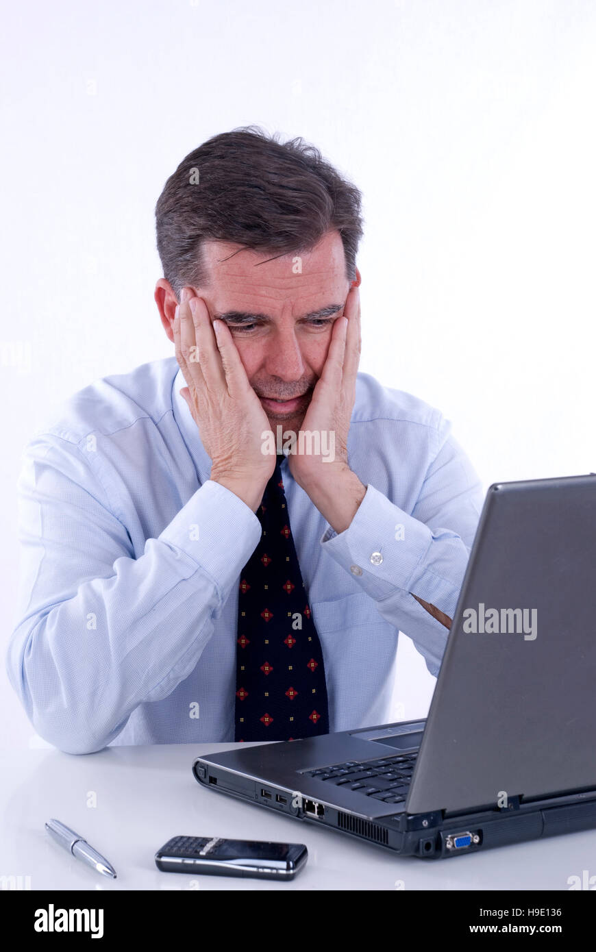 Desperate businessman, over 50, working on a laptop Stock Photo - Alamy