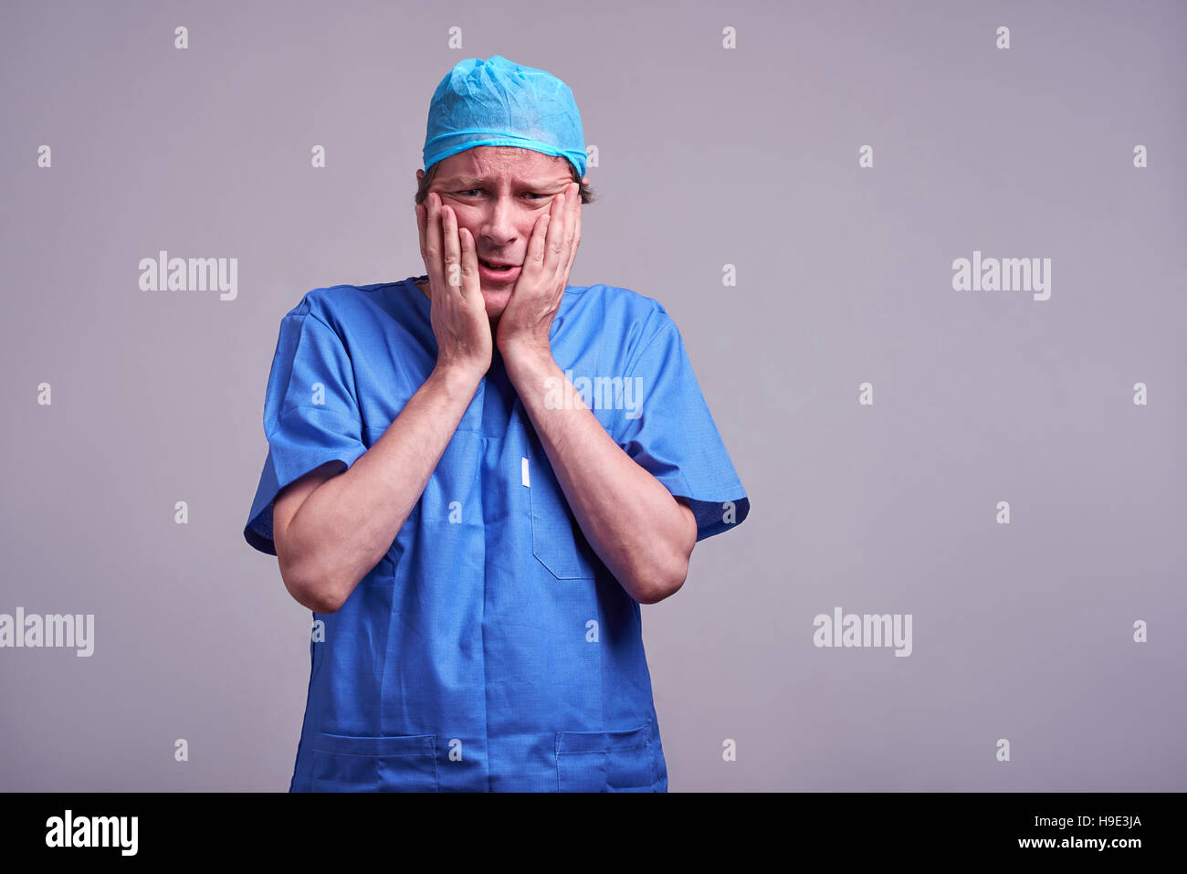 A middle aged male doctor standing and feeling scared Stock Photo - Alamy