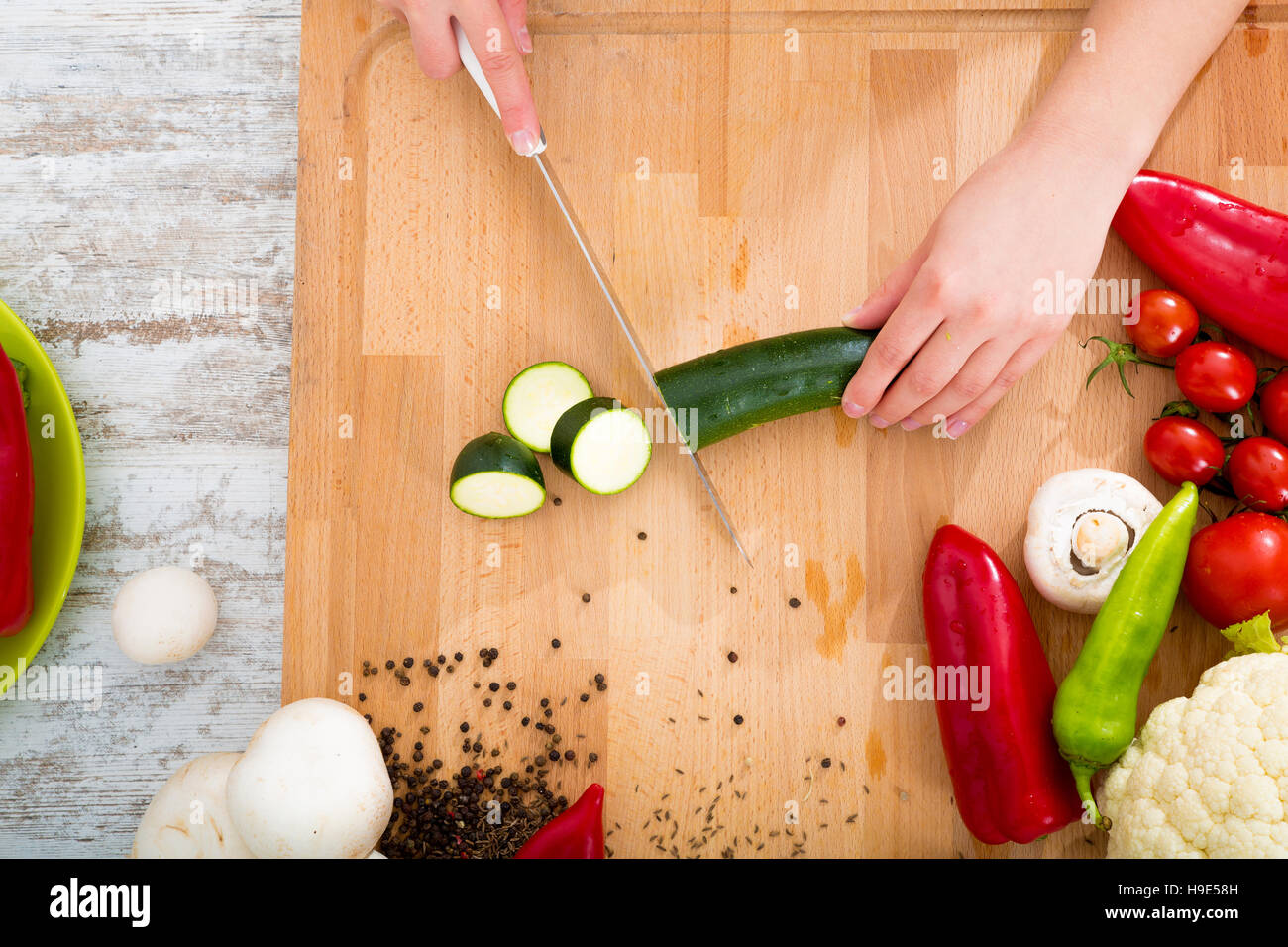 A woman chopping up vegetables at a table Stock Photo - Alamy