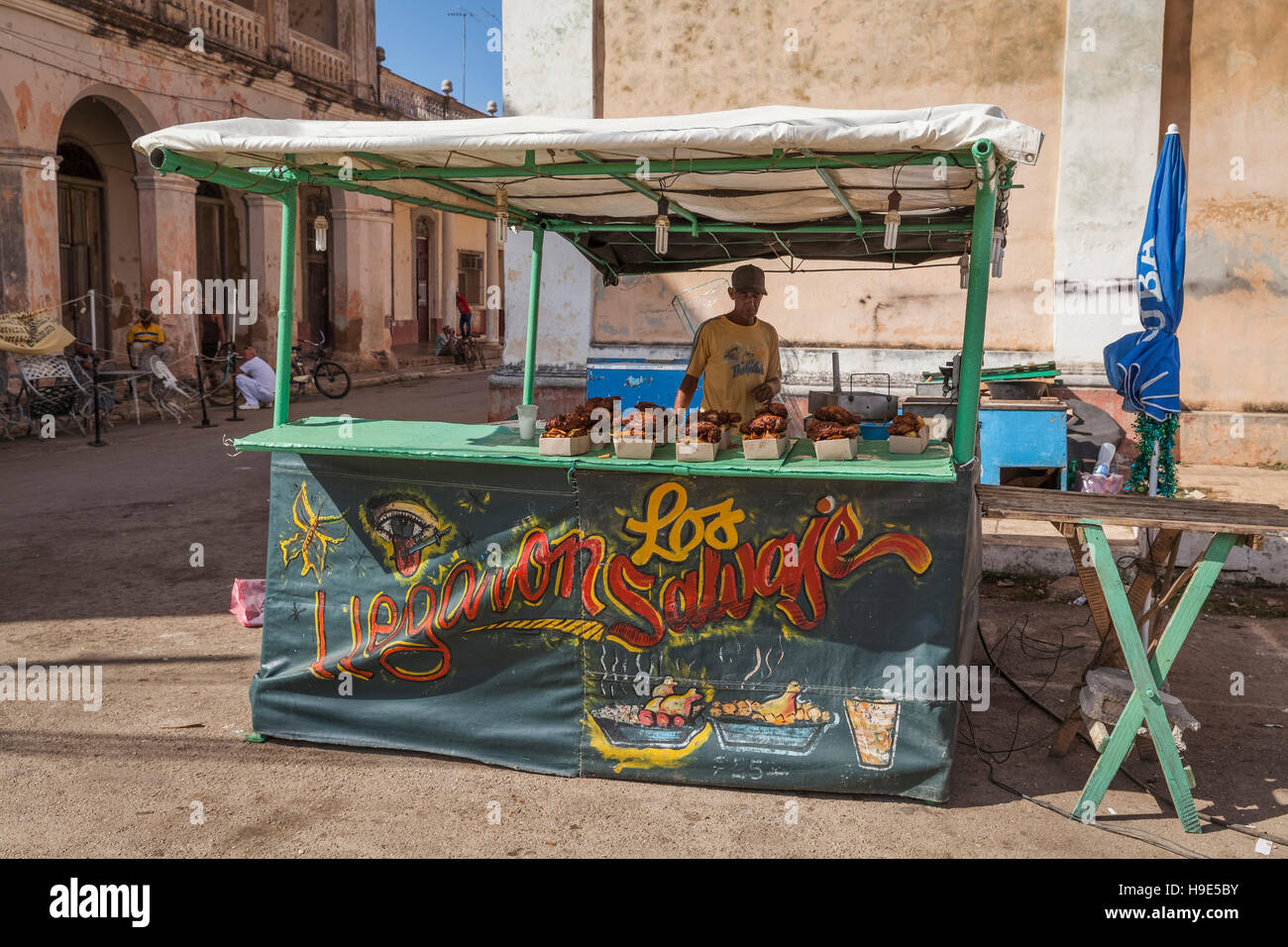 Man selling chicken from a stall in the centre of a town in the middle ...