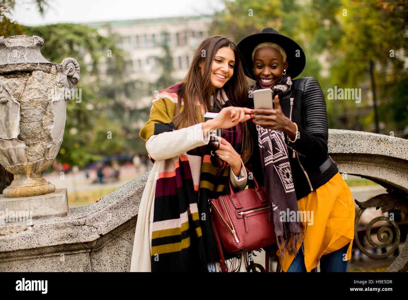 Young African American And Caucasian Women Taking Selfie Outdoor Stock