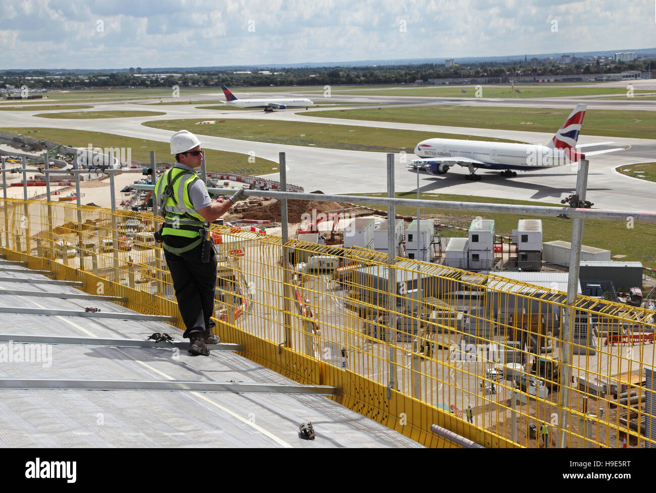 A worker adjusts scaffolding on the roof of the new Terminal 2 building ...