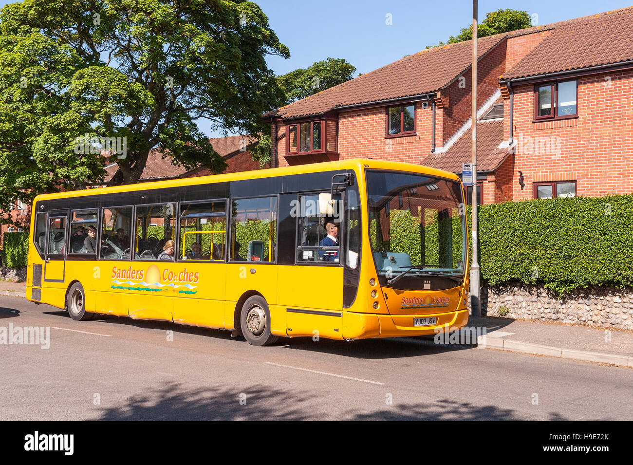 A yellow bus coach at a bus stop in Cromer , Norfolk , England ...