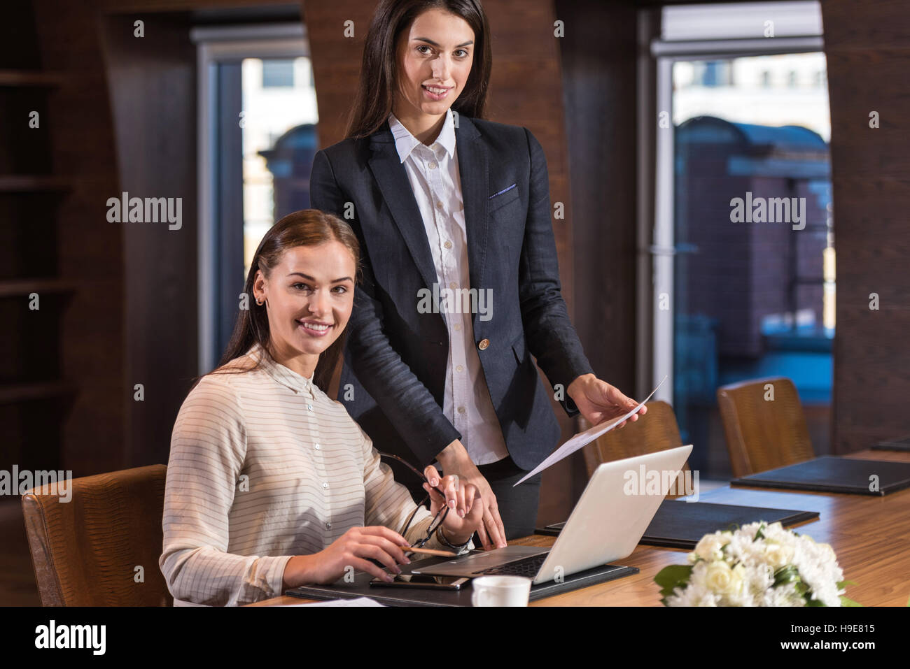 Pretty female colleagues posing in an office Stock Photo - Alamy