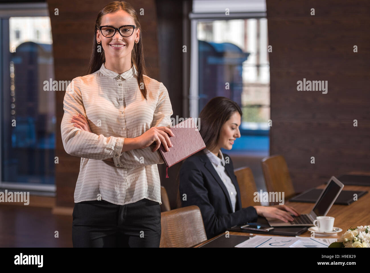 Beautiful female colleagues posing and working together Stock Photo - Alamy