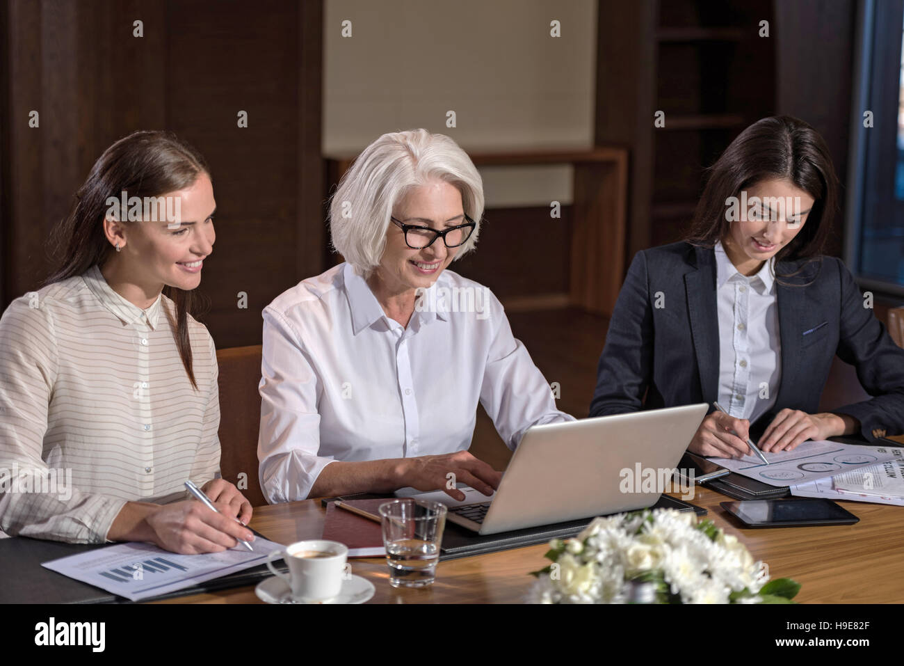 Two young female colleagues and their boss working together Stock Photo ...