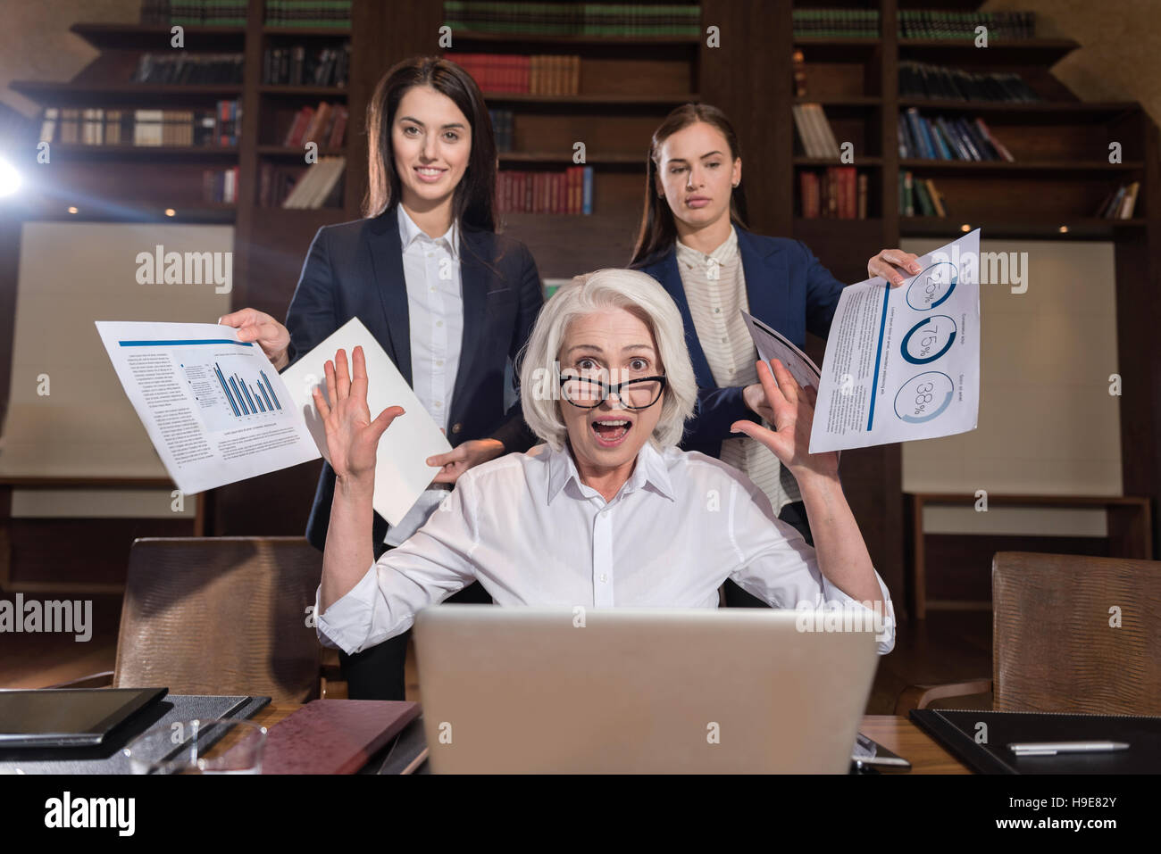 Tired boss and her female colleagues posing in office Stock Photo - Alamy