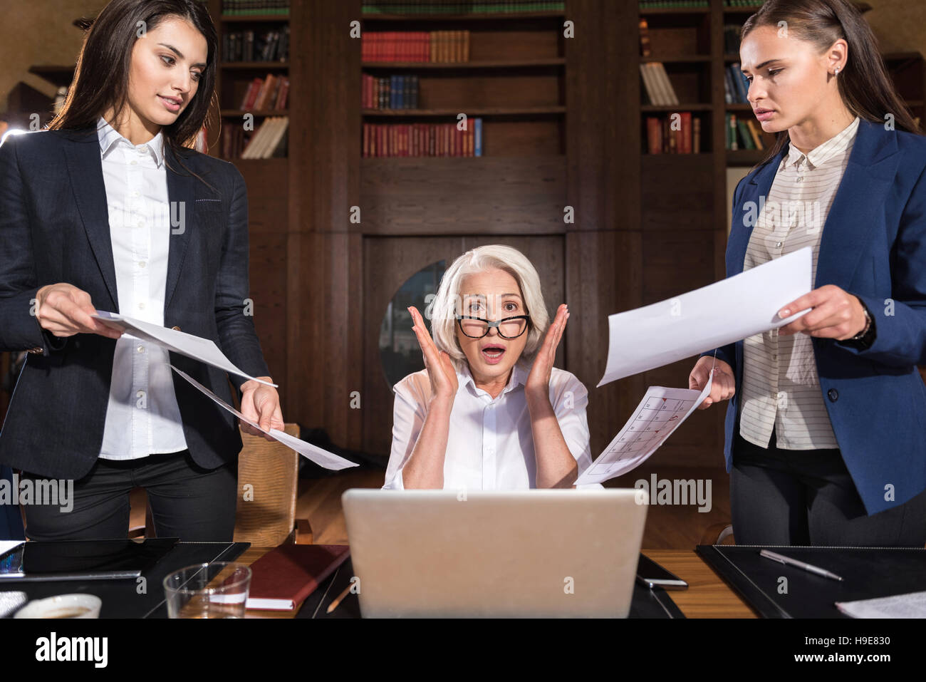 Exhausted boss and her female colleagues posing in an office Stock ...