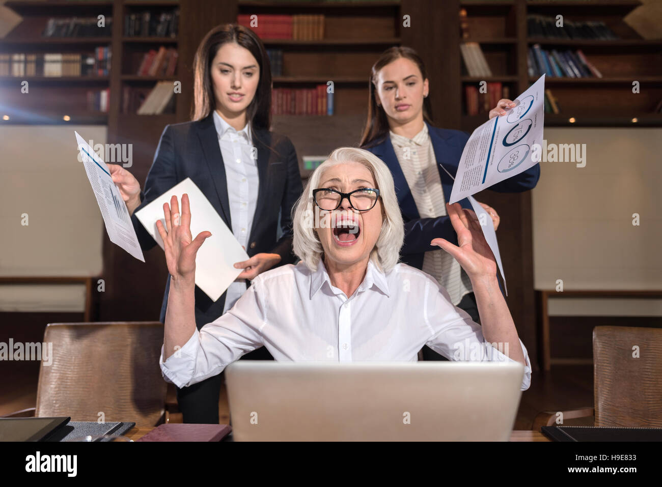 Stressed boss and her female colleagues posing in office Stock Photo ...