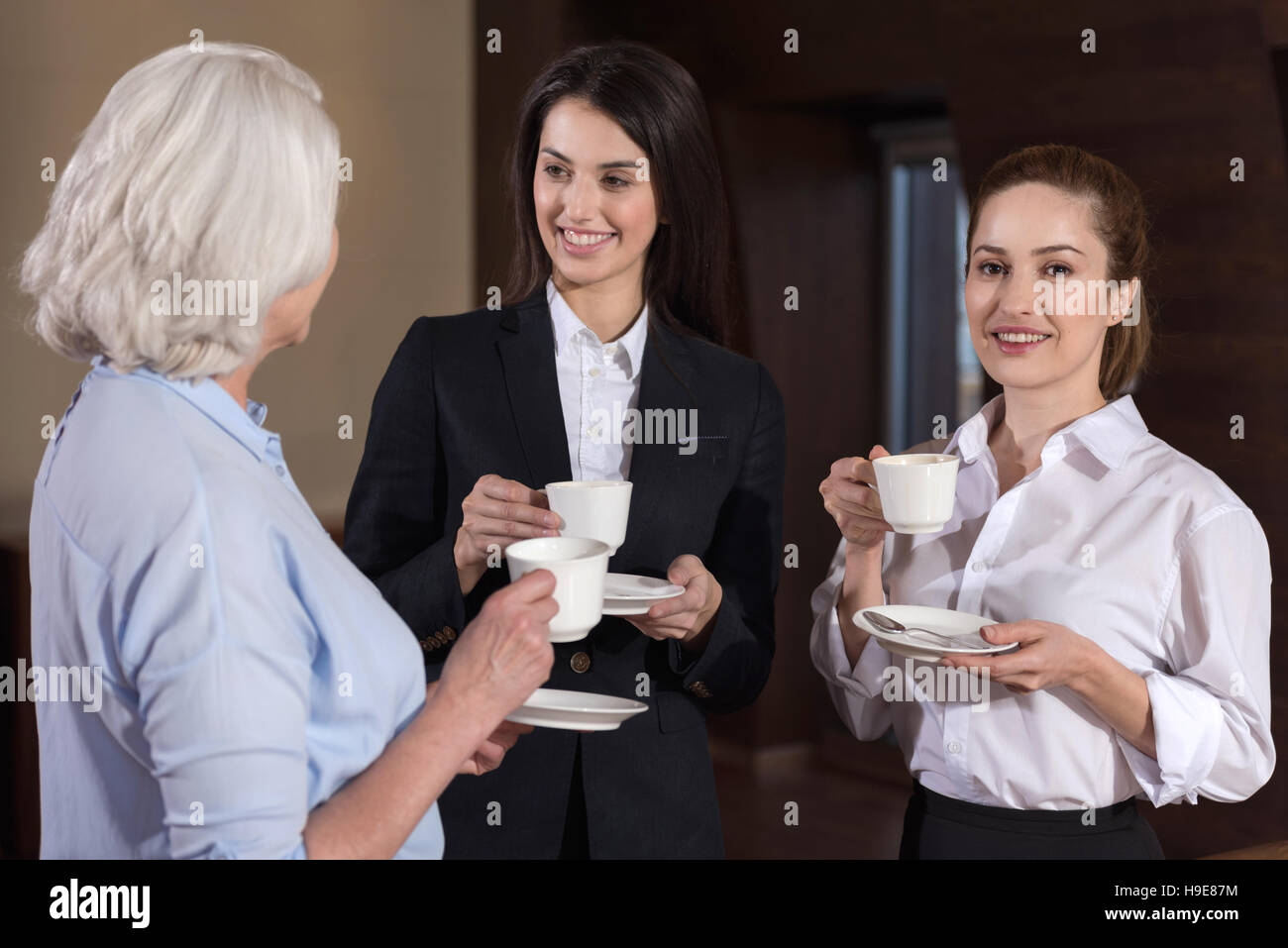 Three colleagues communicating during coffee break at workplace Stock ...