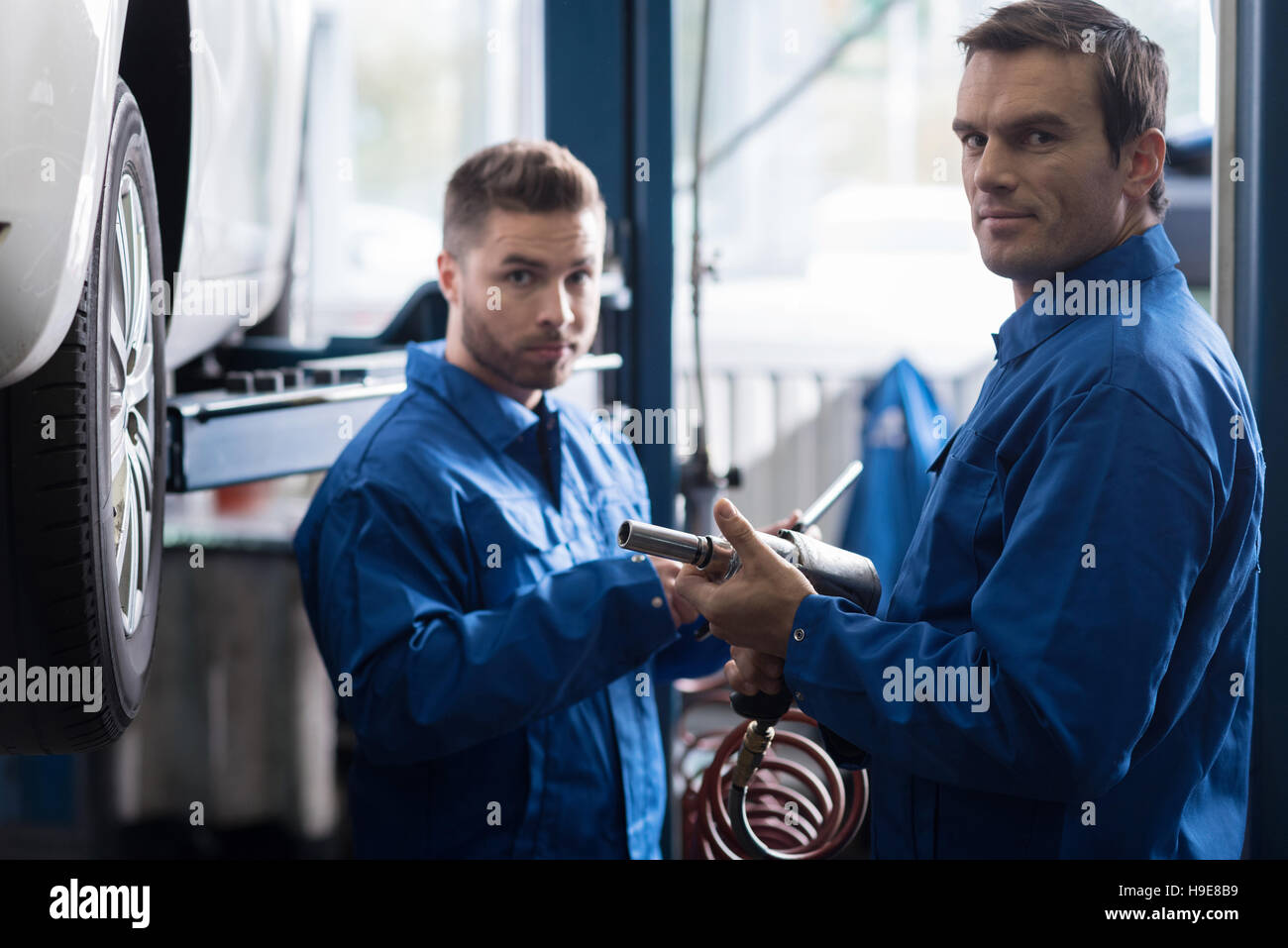Adult concentrated machanic changing car wheel Stock Photo - Alamy