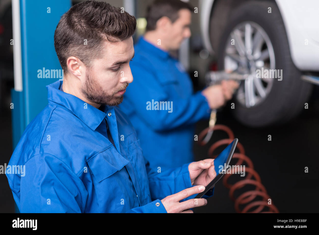 Young car mechanic using tablet Stock Photo - Alamy