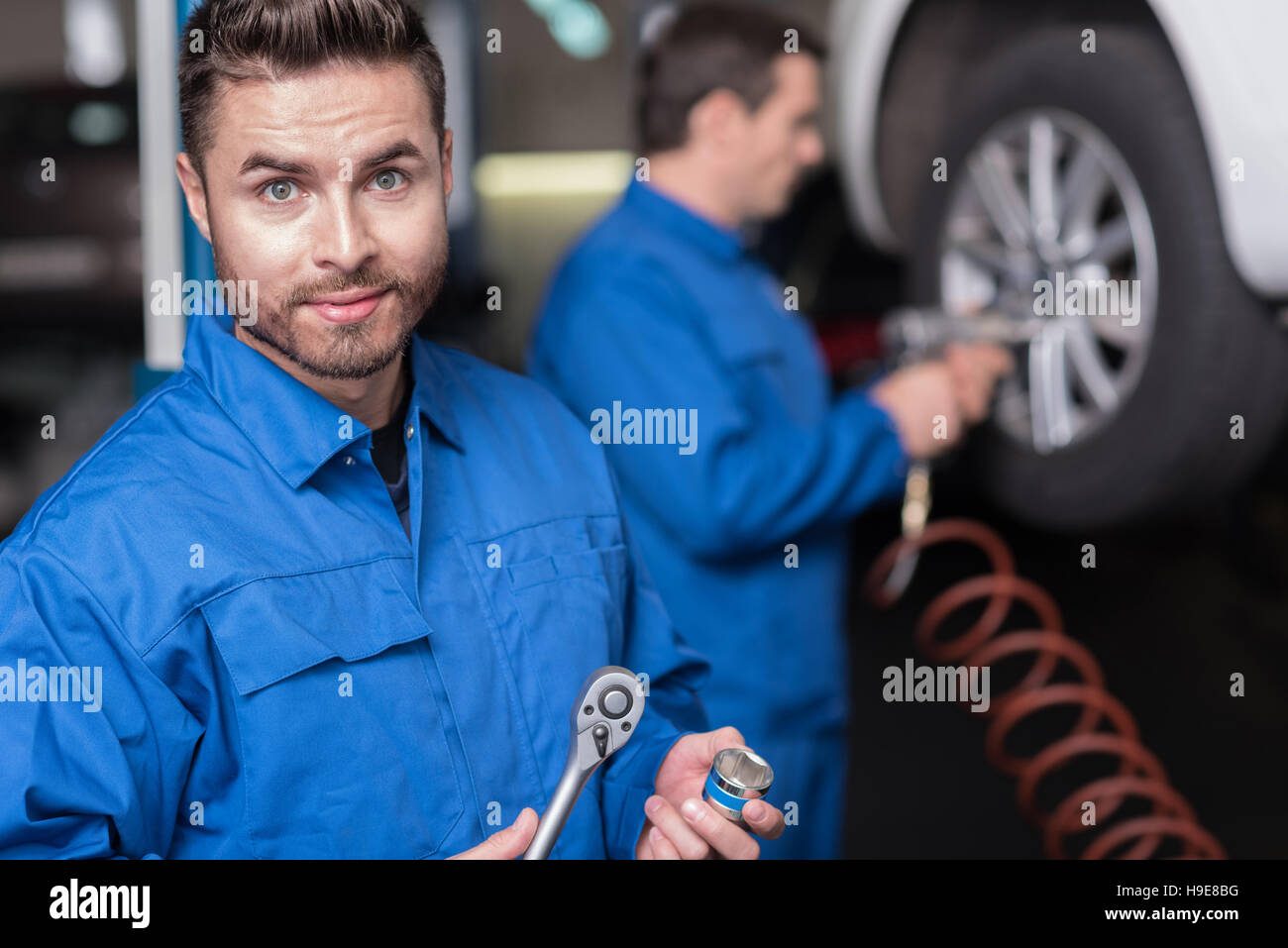 Professional car mechanic holding tools Stock Photo - Alamy