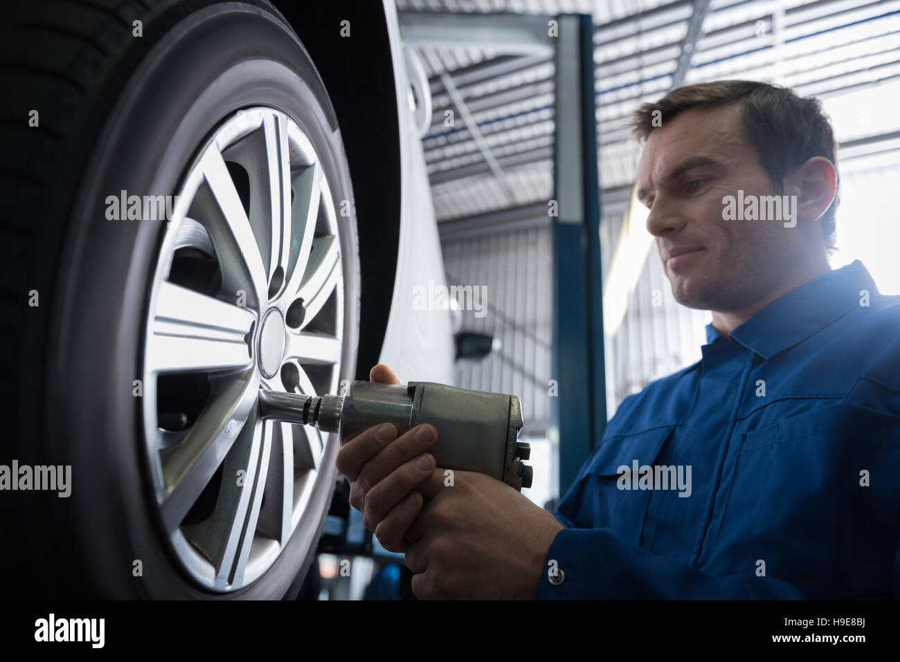 Professional mechanic changing car wheel Stock Photo - Alamy