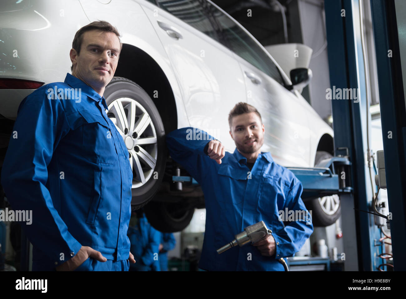 Handsome car mechanic going to changethe wheel Stock Photo - Alamy