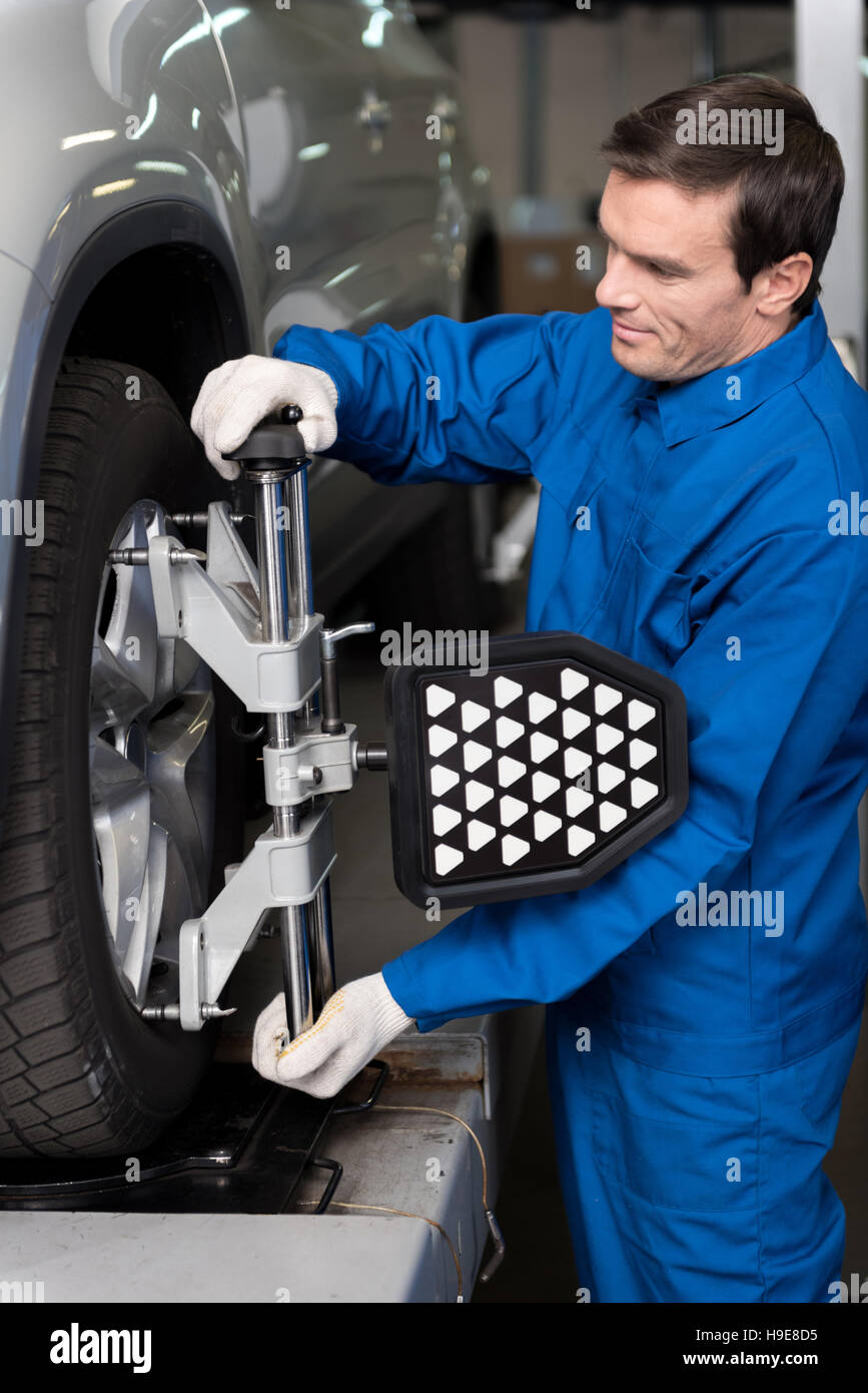 Professional mechanic adjusting automobile wheel system Stock Photo - Alamy