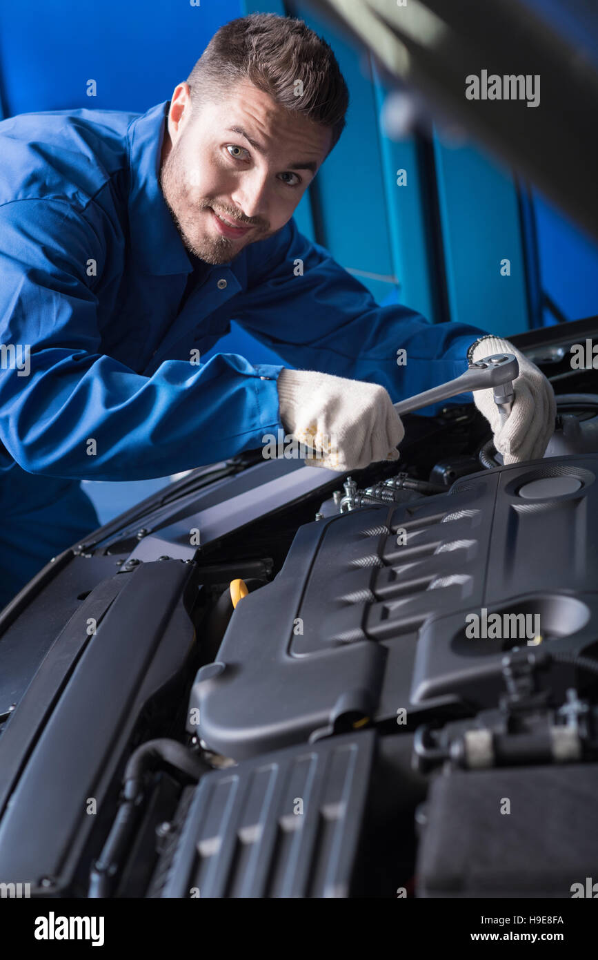 Cheerful handsome mechanic working in auto center Stock Photo - Alamy