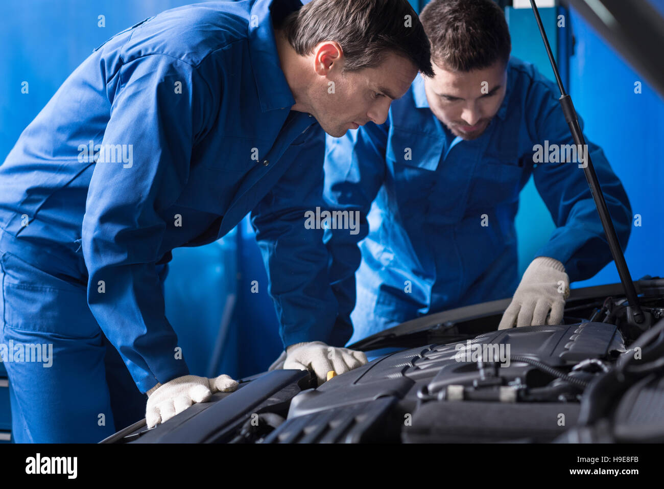 Professional mechanics discussing break out in car engine Stock Photo ...